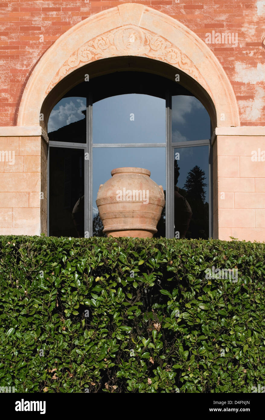 Ornamental vase on the window behind the hedge Stock Photo - Alamy