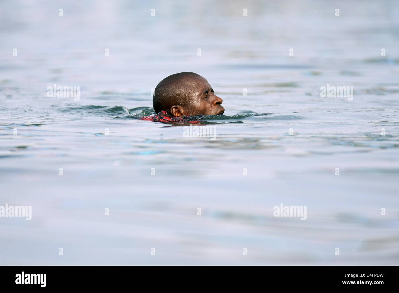 Luis Fortunato Pavavira from Angola swims inthe water after falling out ...