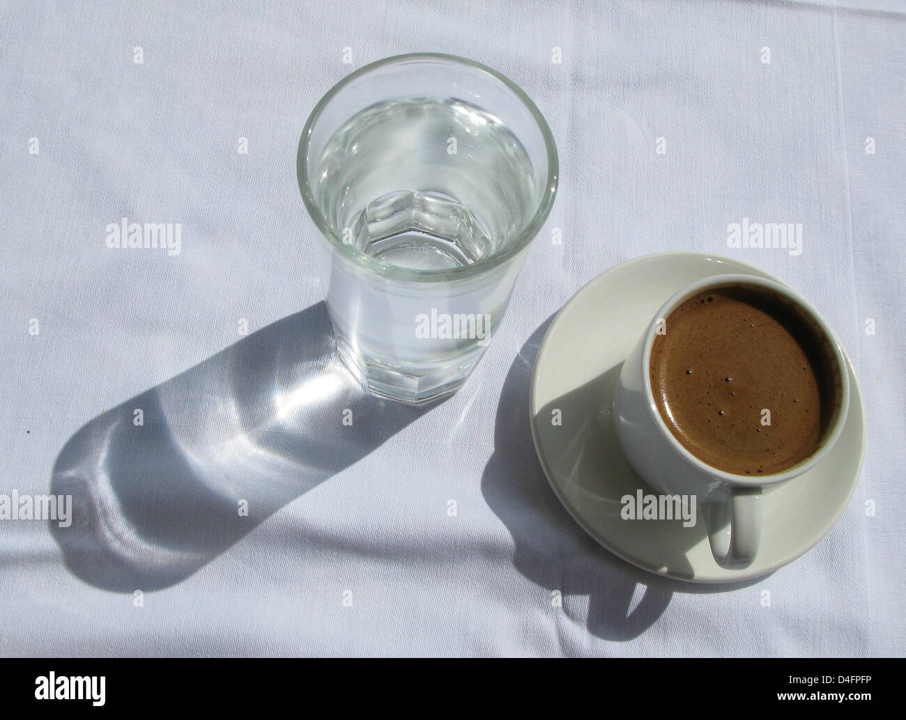 A typical Greek coffee (Kafe elliniko) and a glass of water seen on a ...