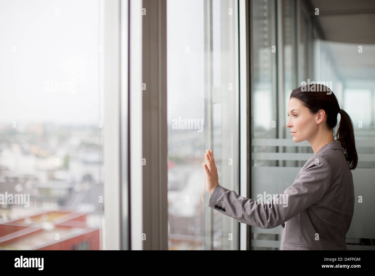 Businesswoman standing at office window Stock Photo - Alamy