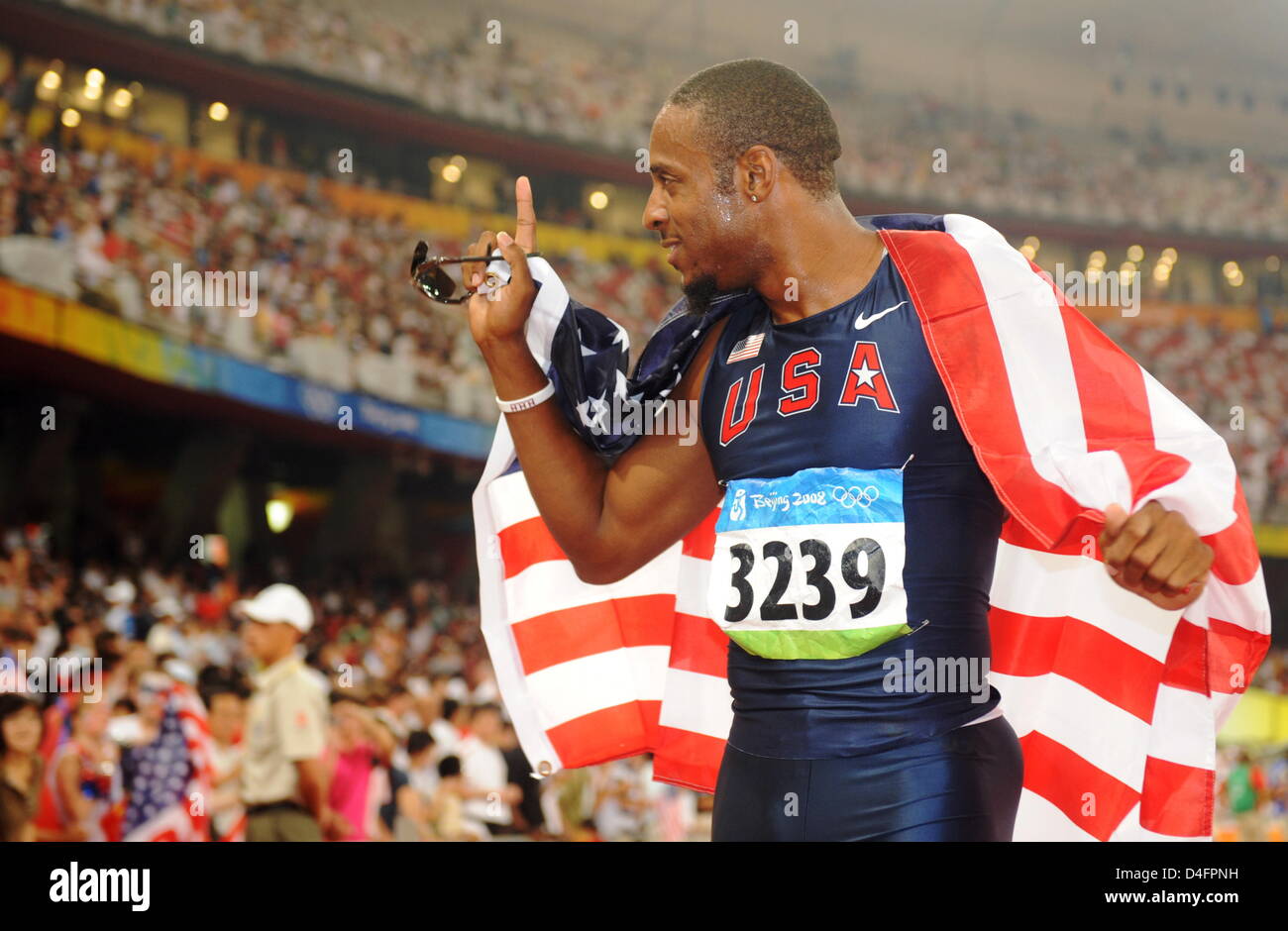 Angelo Taylor celebrates with a US flag after winning Men's 400m ...