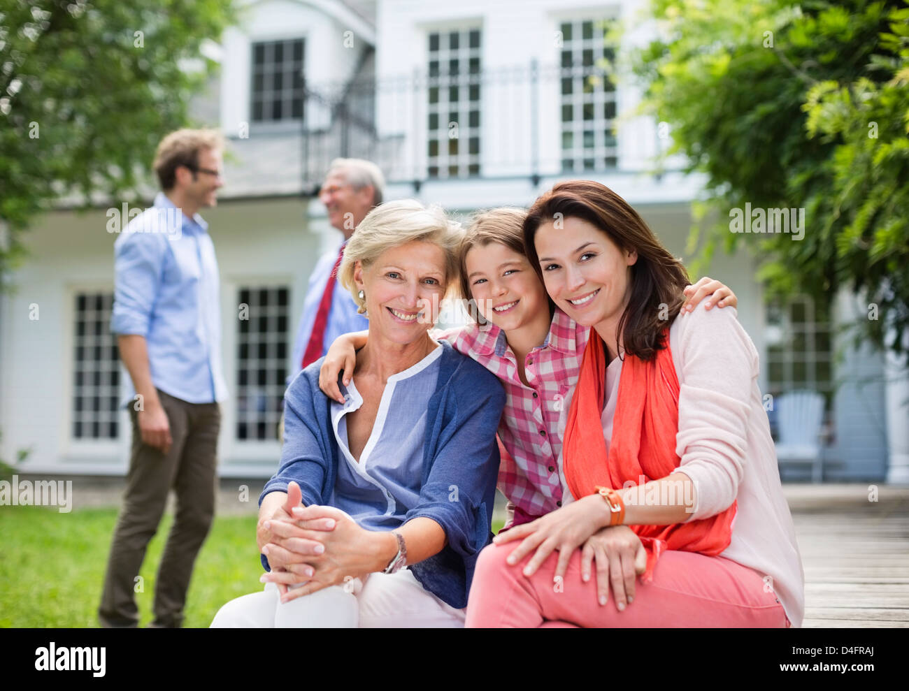 Family smiling together outside house Stock Photo - Alamy