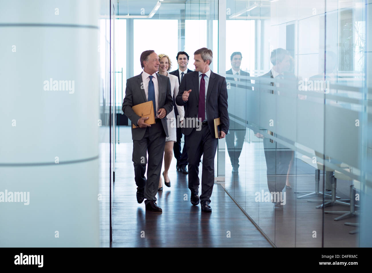 Businesspeople walking in hallway Stock Photo - Alamy