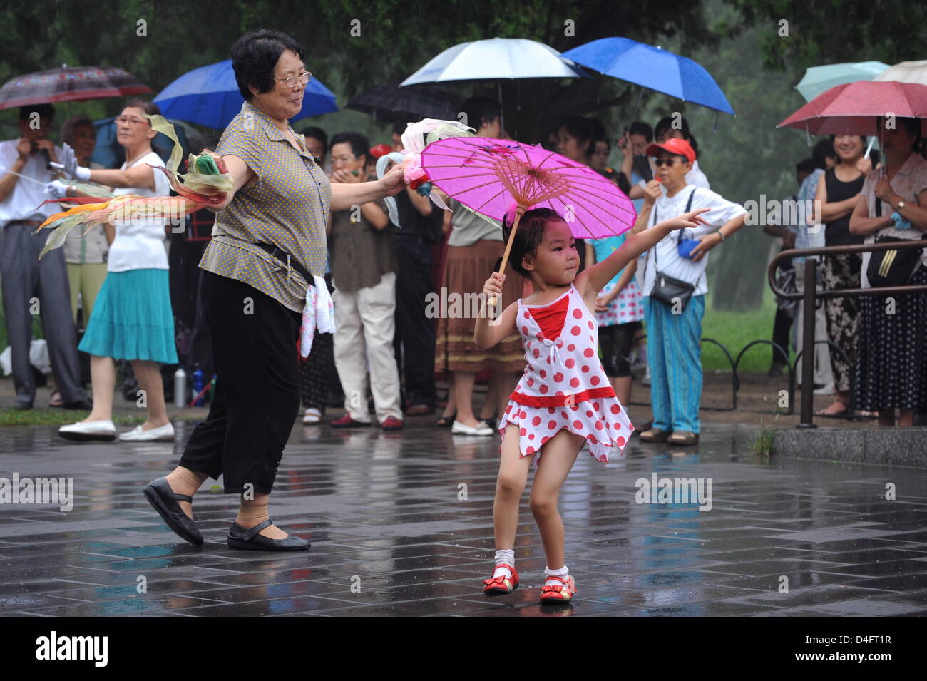 Chinese women and children dance in the rain at the Tempel of Heaven in ...