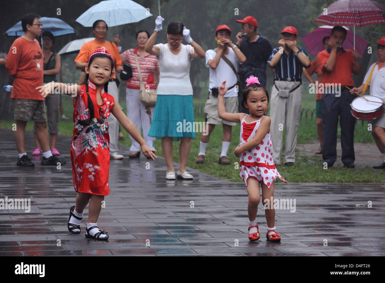 Chinese children dance in the rain outside Tempel of Heaven in Beijing ...
