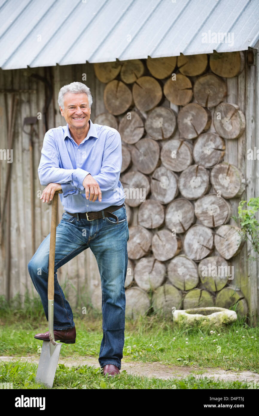 Full length portrait of a man standing with forklift truck in ...