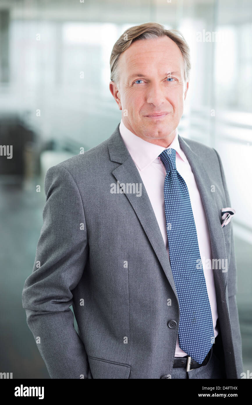 Businessman standing in office hallway Stock Photo - Alamy