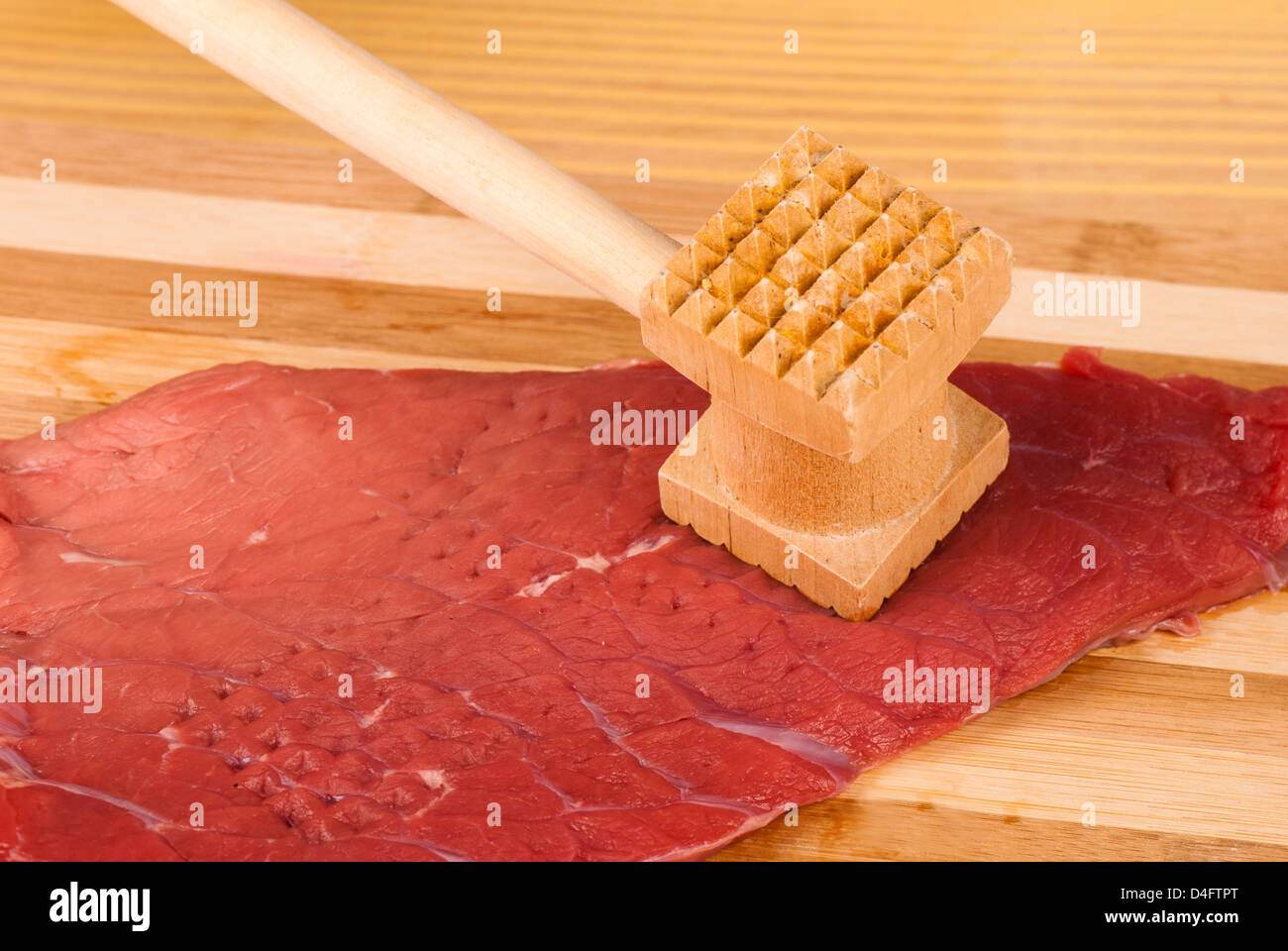 Hands tenderizing meat with a kitchen hammer Stock Photo - Alamy