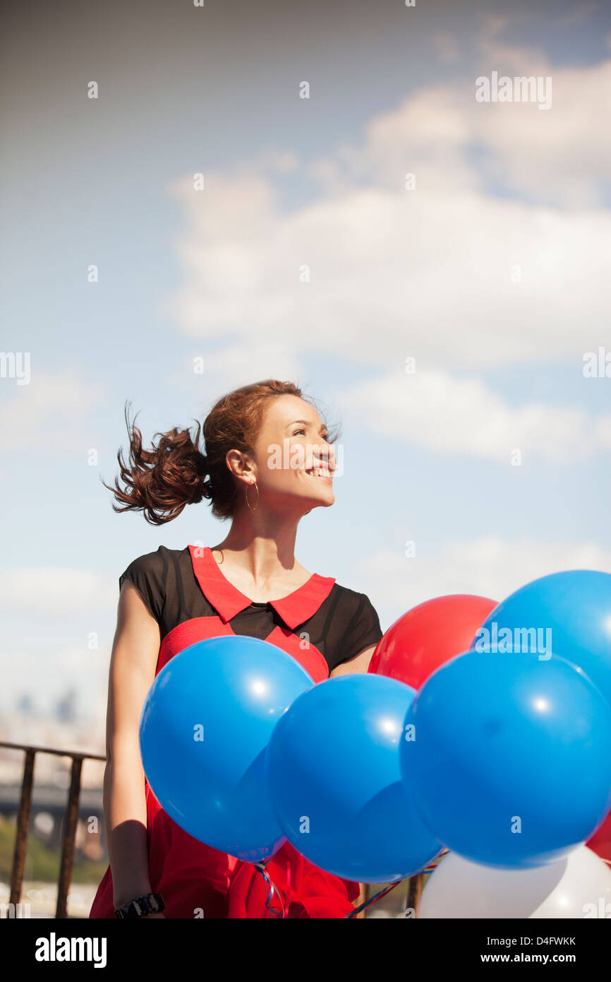 Woman carrying bunch of balloons Stock Photo - Alamy