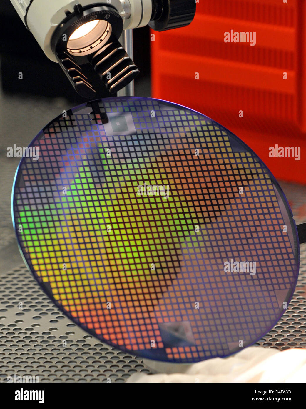 Micro technology student Daniel Foelsch examines a so called 'Wafer' at ...