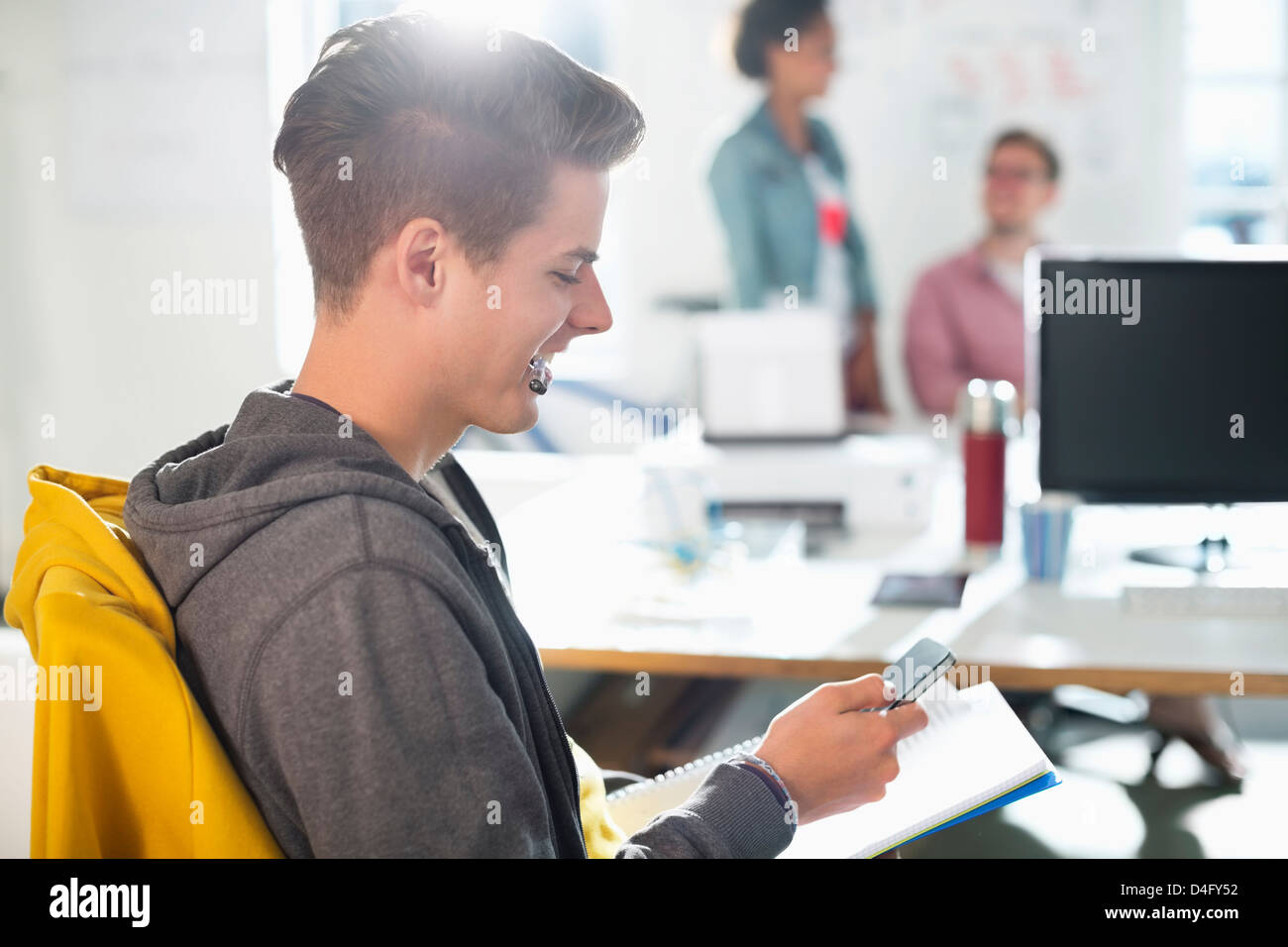 Man sitting on chair looking at phone side view hi-res stock ...