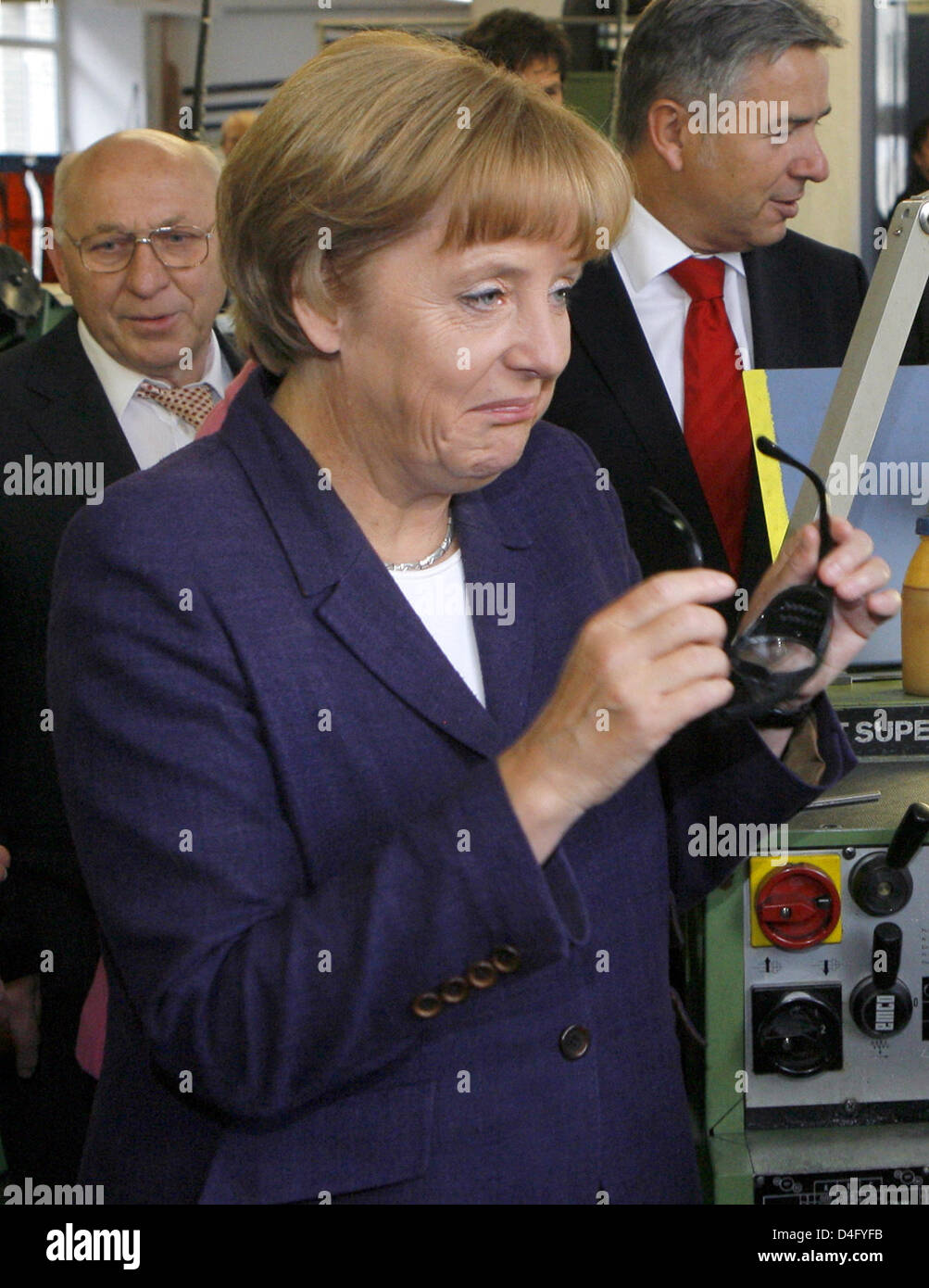 German Chancellor Angela Merkel puts on a pair of goggles as she stands ...