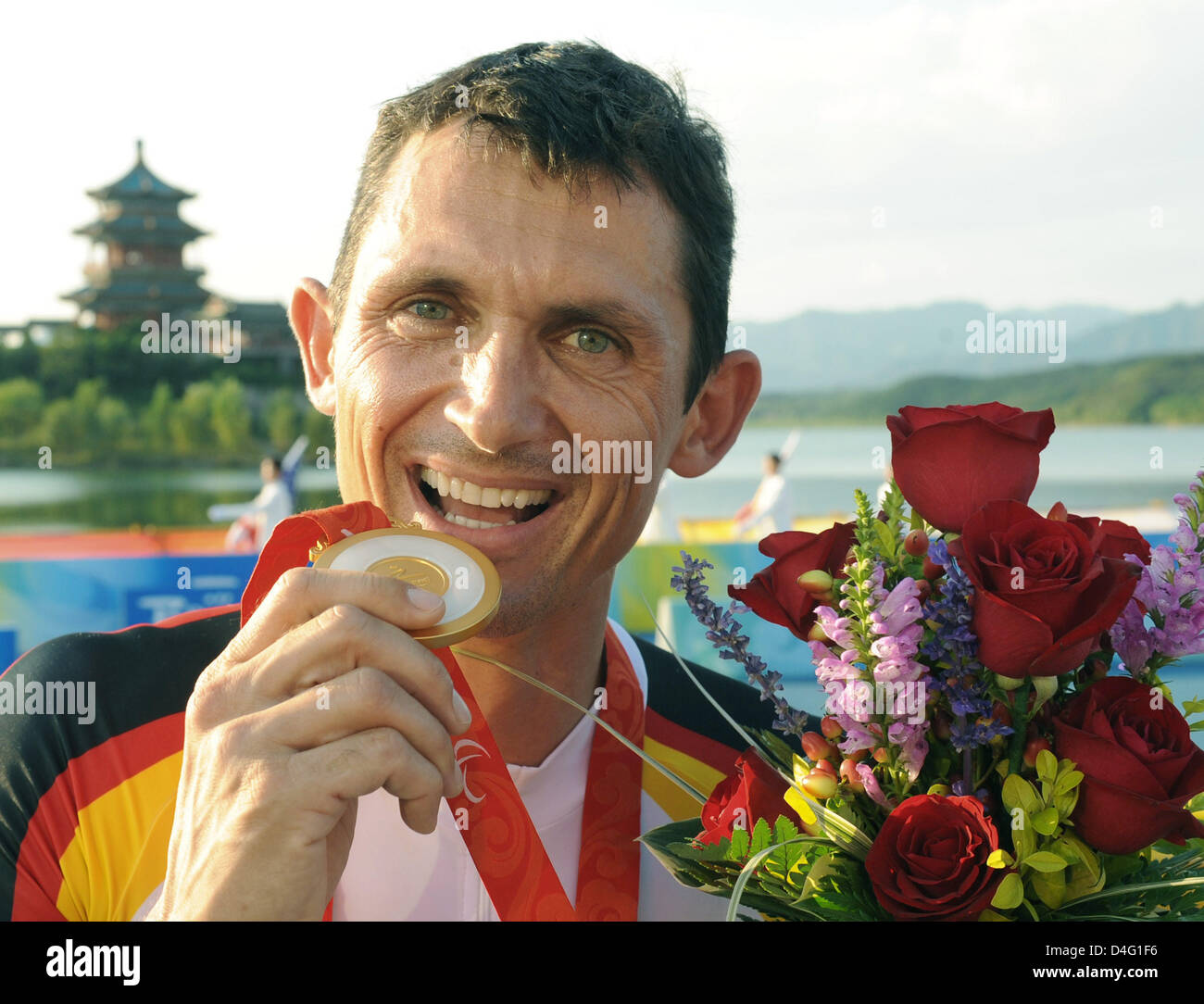 Michael Teuber from Germany bites into his gold medal after his victory ...