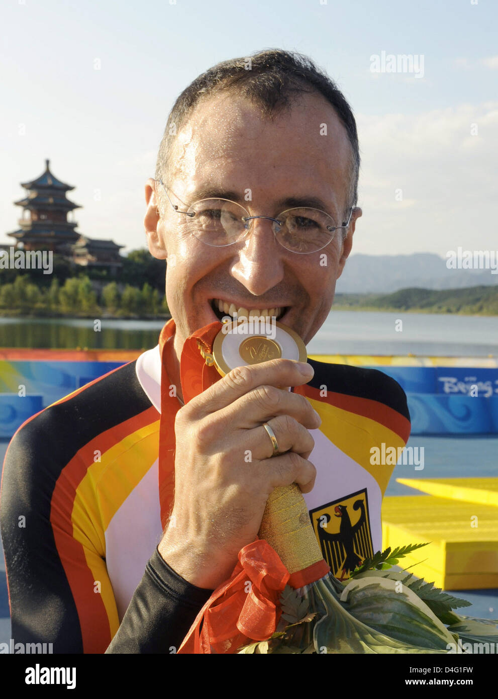 Wolfgang Sacher from Germany bites into his gold medal after the award ...
