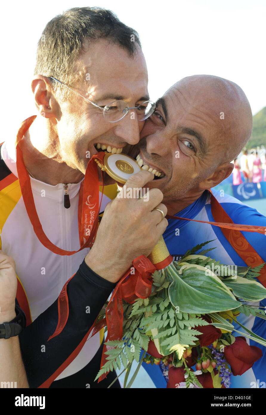 Bronze medal winner Fabio Triboli (R) from Italy bites into the gold ...