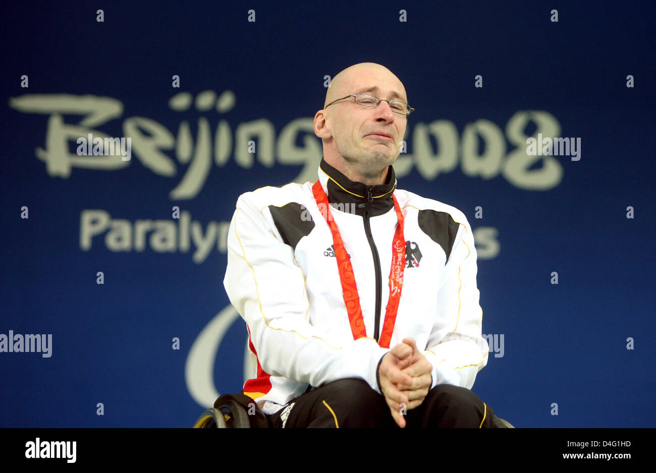 German swimmer Thomas Grimm wipes off a tear during the 100m ...