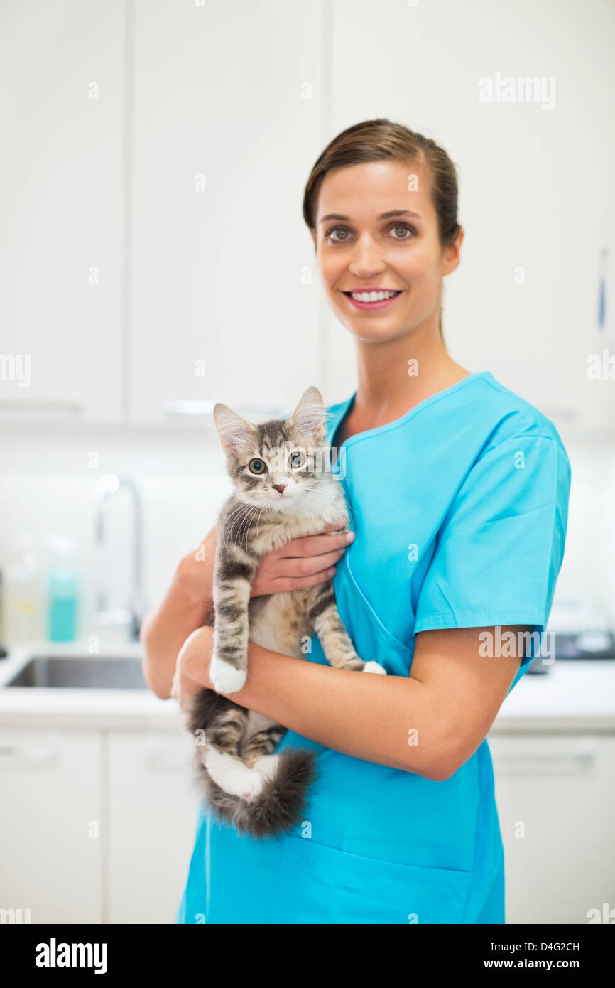 Smiling Veterinarian holding cat in vet's surgery Stock Photo - Alamy