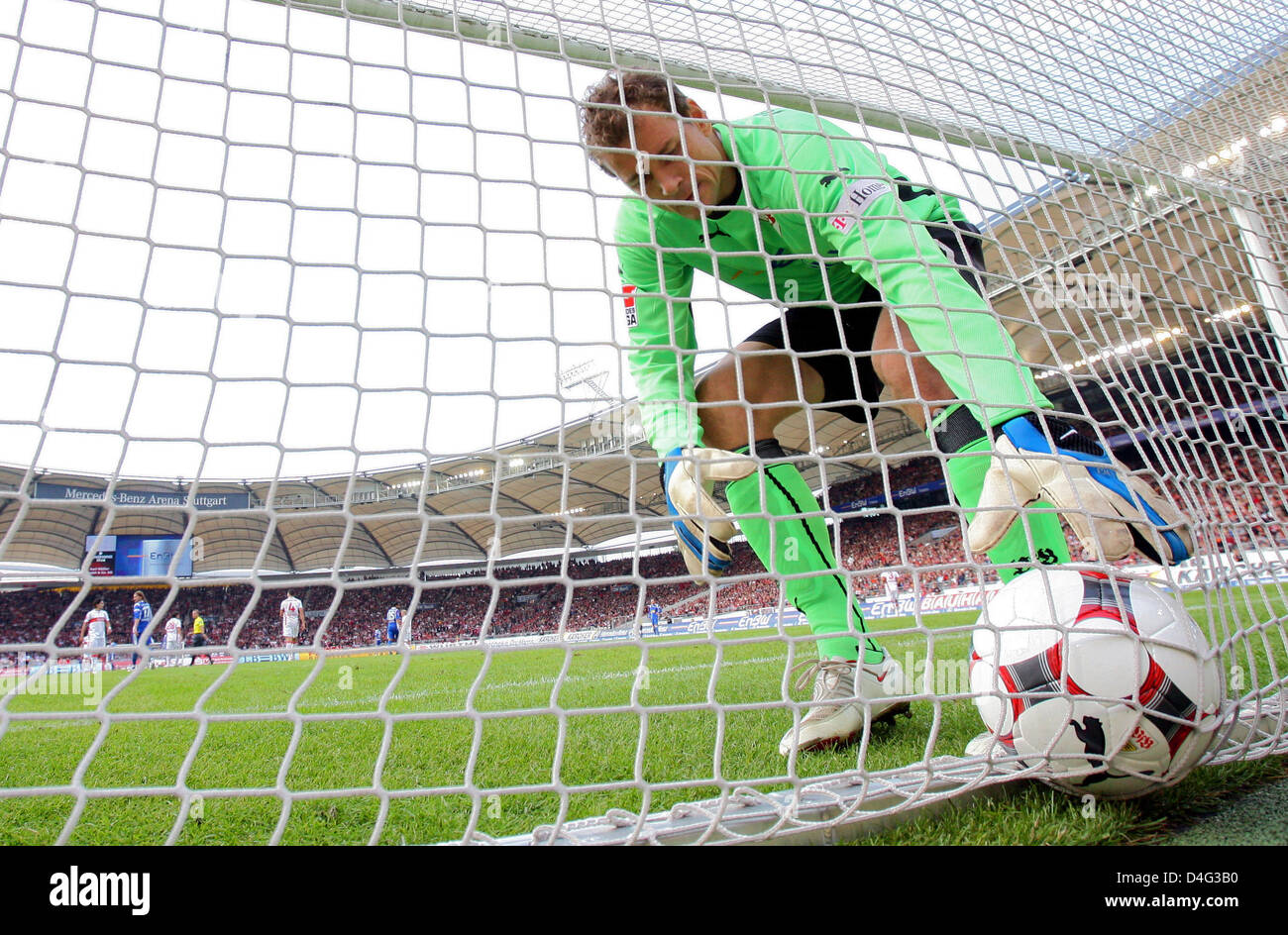 Stuttgart's goalkeeper Jens Lehmann picks up a ball from his goal ...