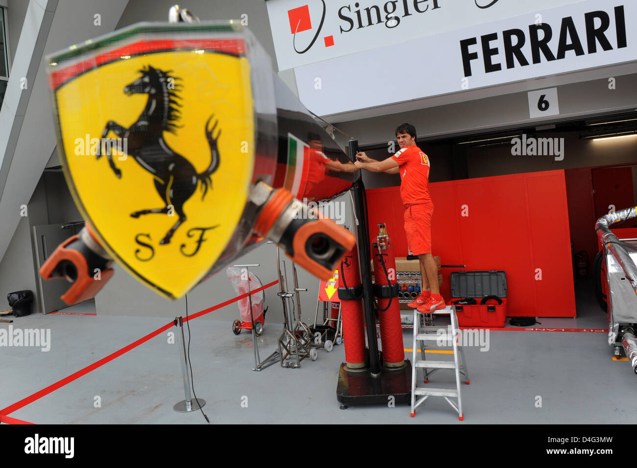 A mechanic of Ferrari works in front of the team's pit to prepare for ...