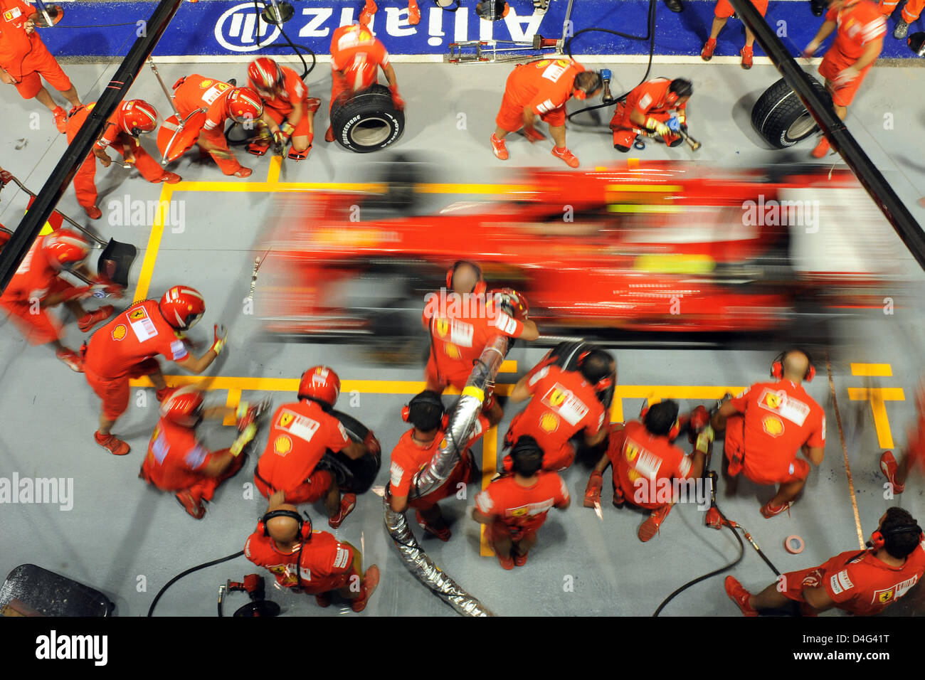 The pit crew of Scuderia Ferrari practices a pit stop at Marina Bay ...
