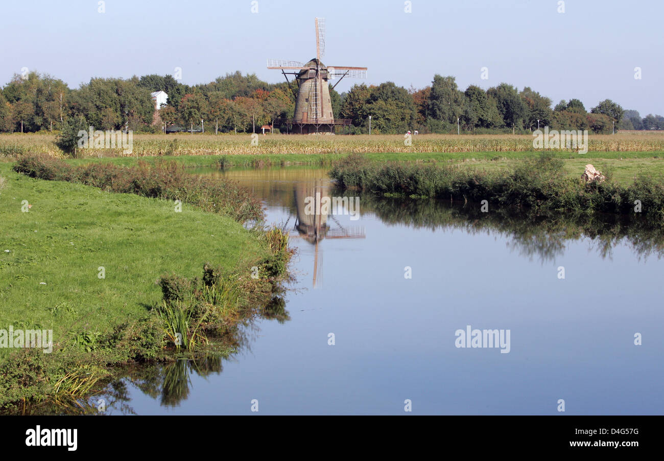 The photo shows a view of the 'Vechte' with a windmill in the ...