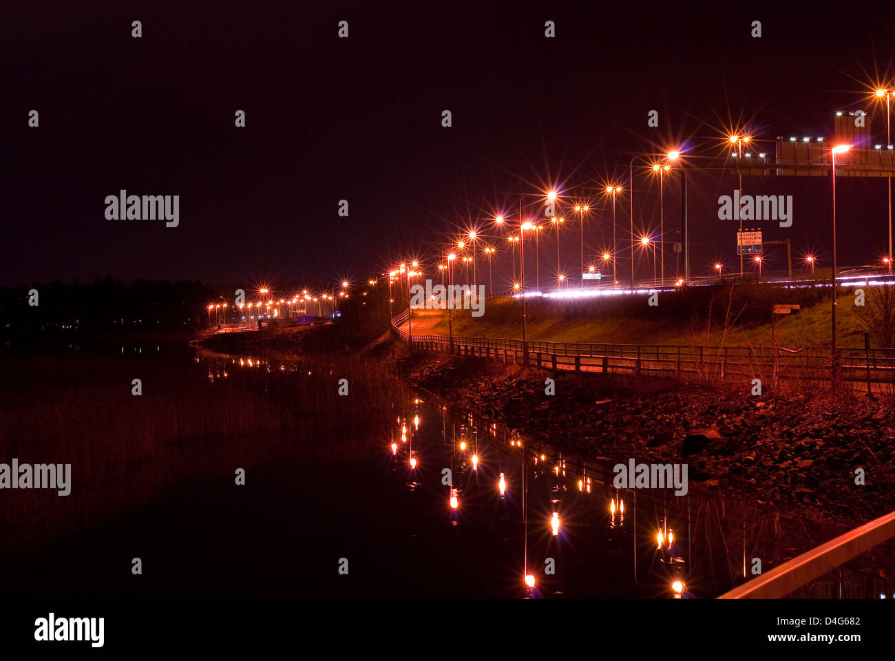 Street lights illuminating the motorway and casting a reflection in the ...