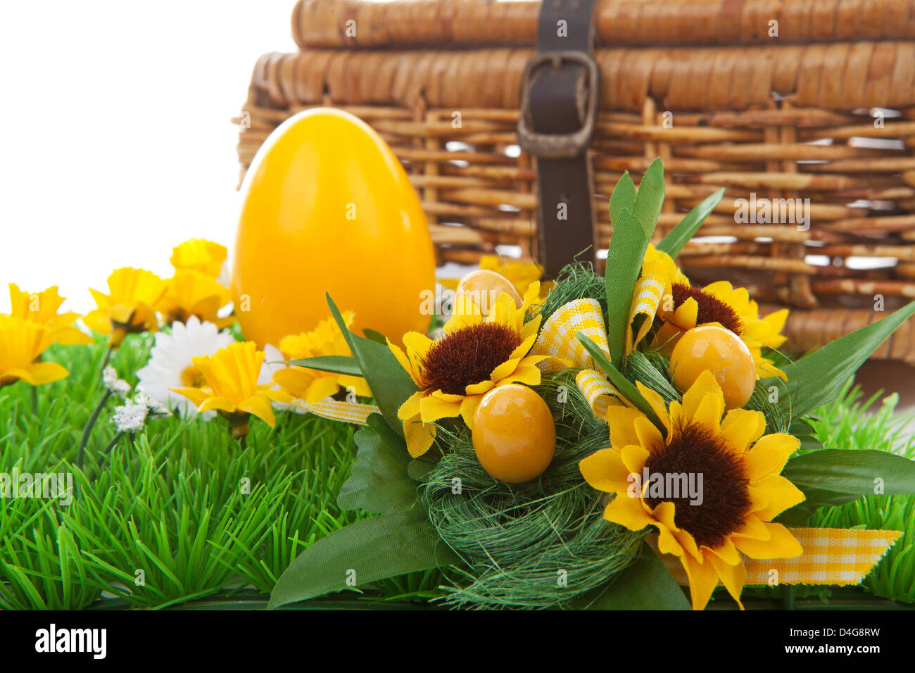 Yellow easter egg and basket on green grass with flowers Stock Photo ...