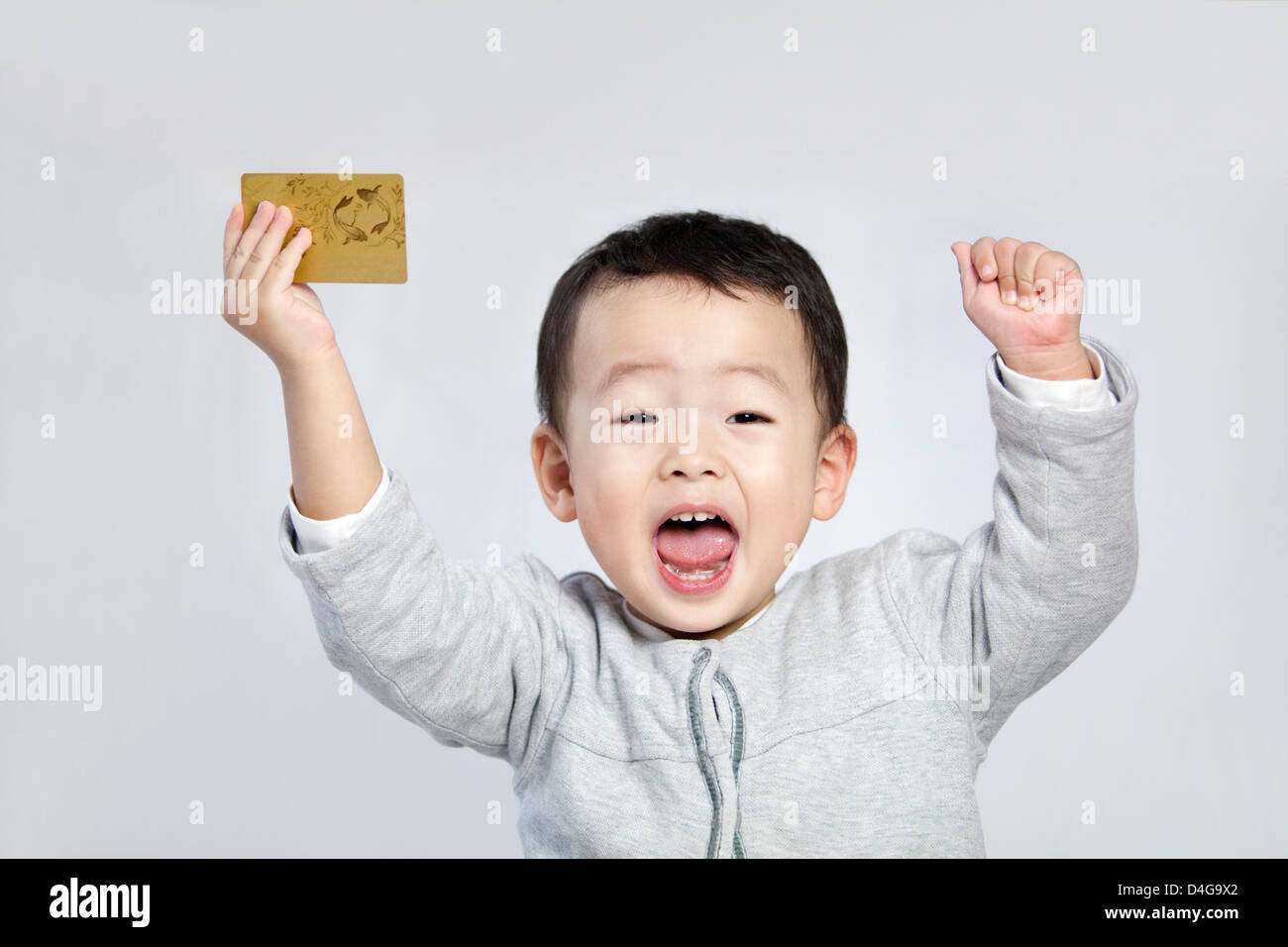 Little boy with bank card cheering with excitement Stock Photo - Alamy