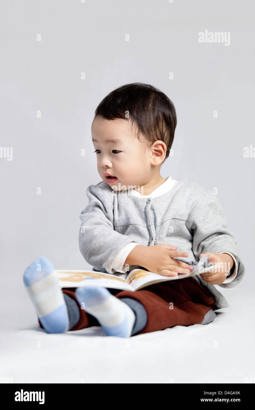 Cute little boy reading a book Stock Photo - Alamy