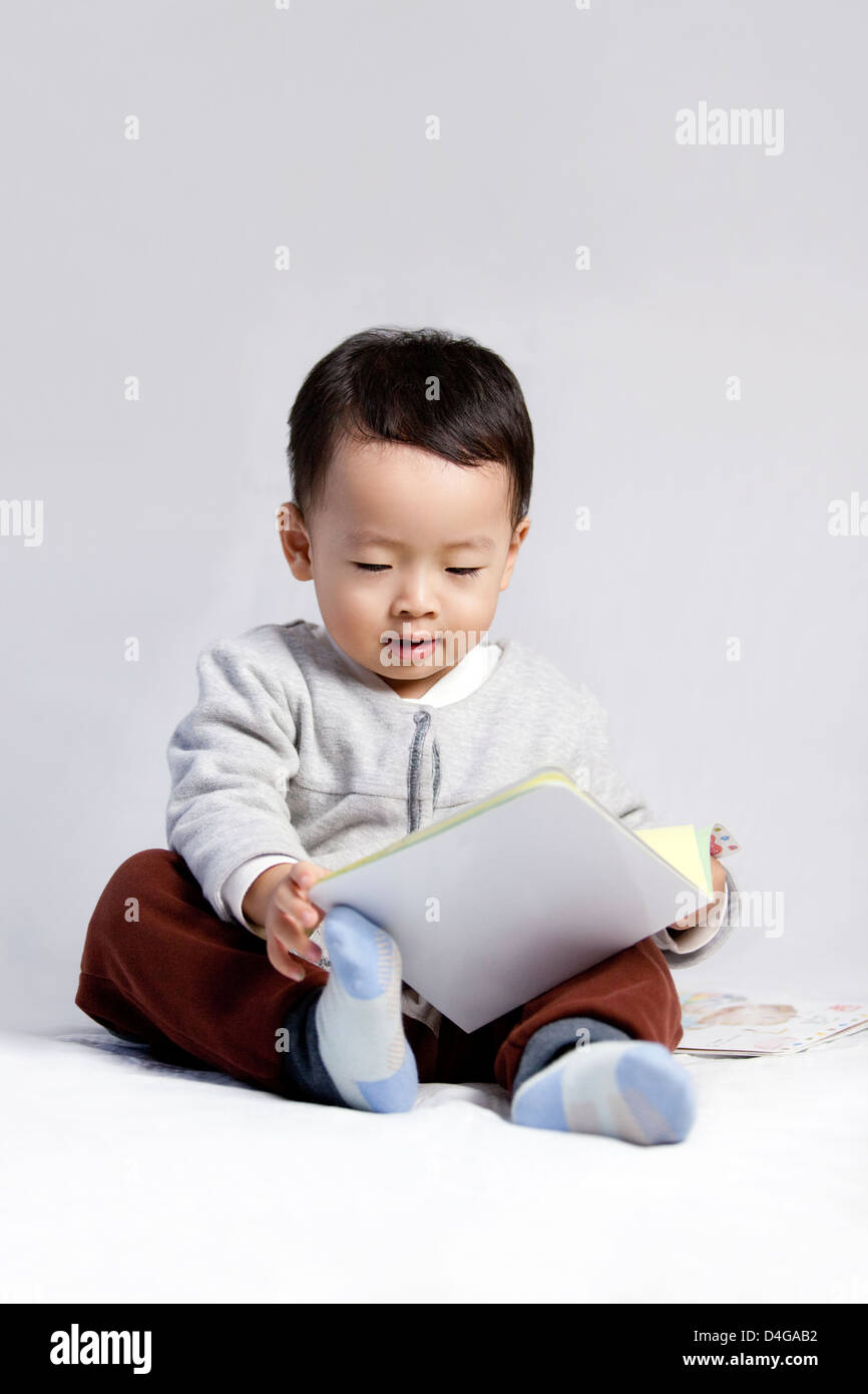 Cute little boy reading a book Stock Photo - Alamy