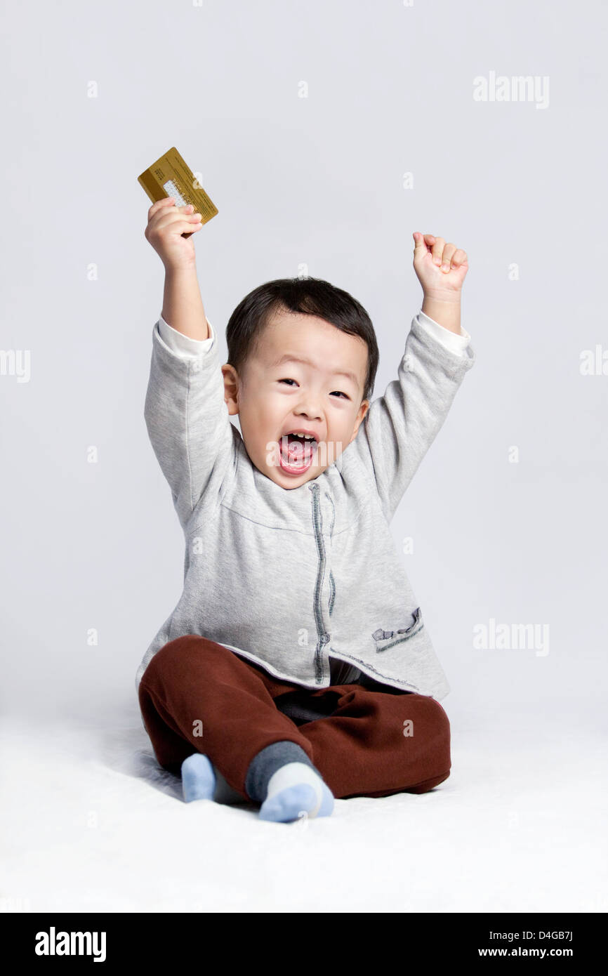 Little boy with bank card cheering with excitement Stock Photo - Alamy