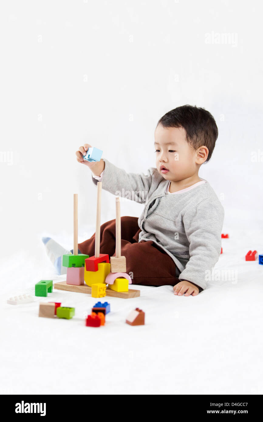 Cute little boy piling up building blocks Stock Photo - Alamy