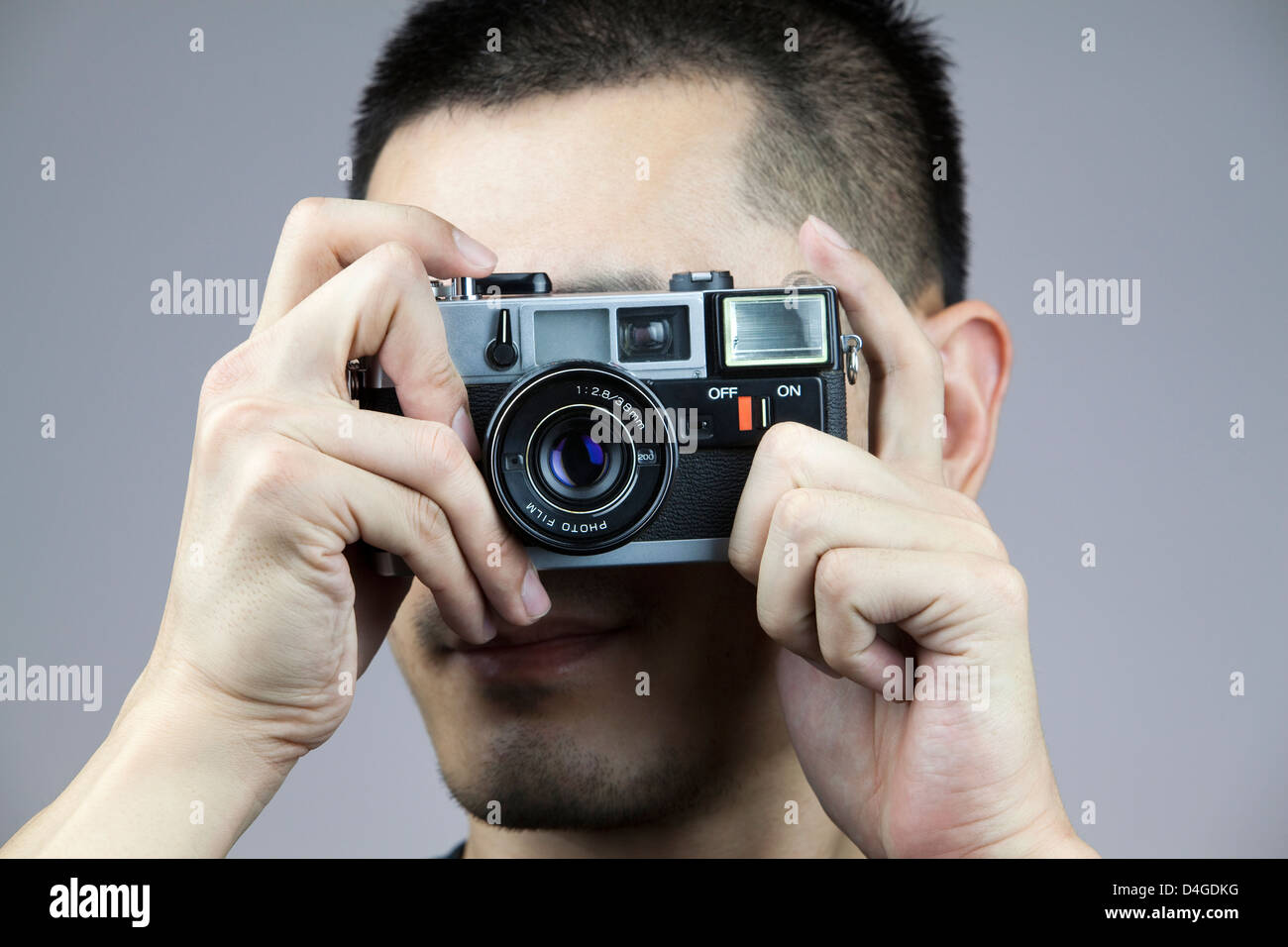 Young man taking photos with old-fashioned camera Stock Photo - Alamy