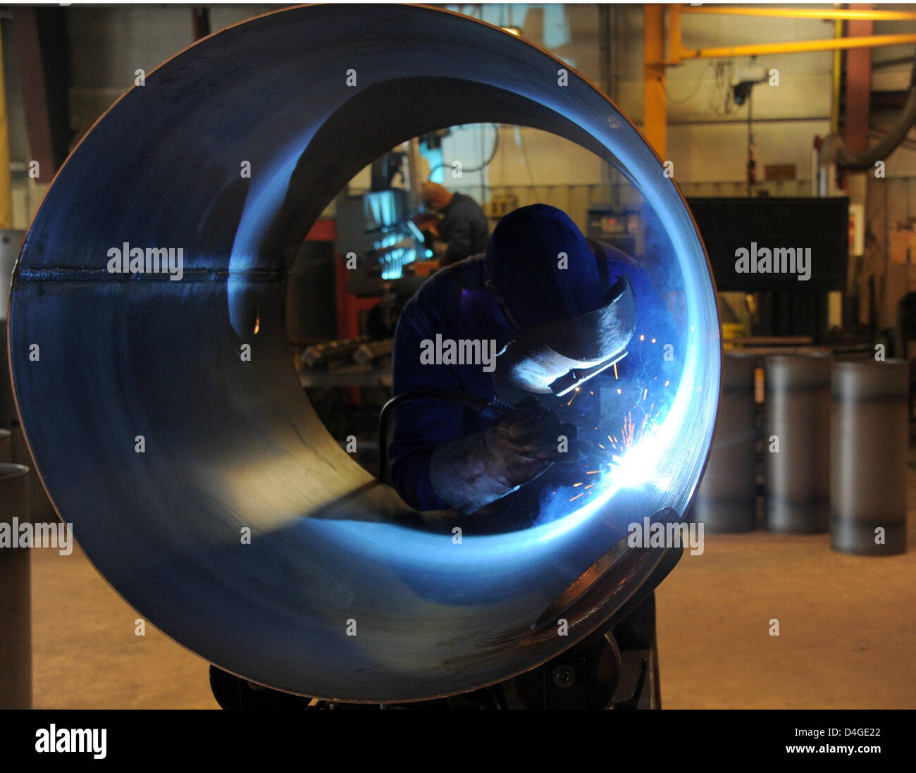 A welder works on a large metal pipe at the container manufacturer Huch ...