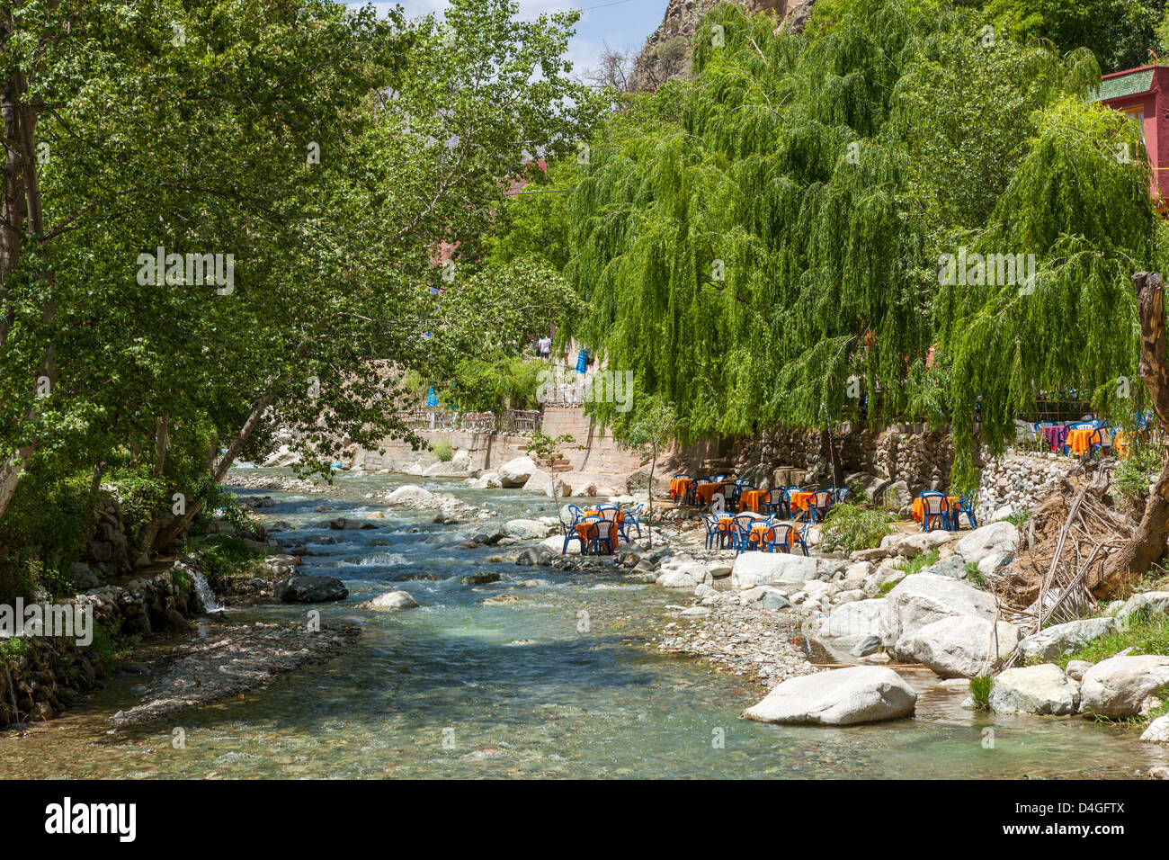Chairs and a table at a restaurant patio overlooking mountain rapids ...