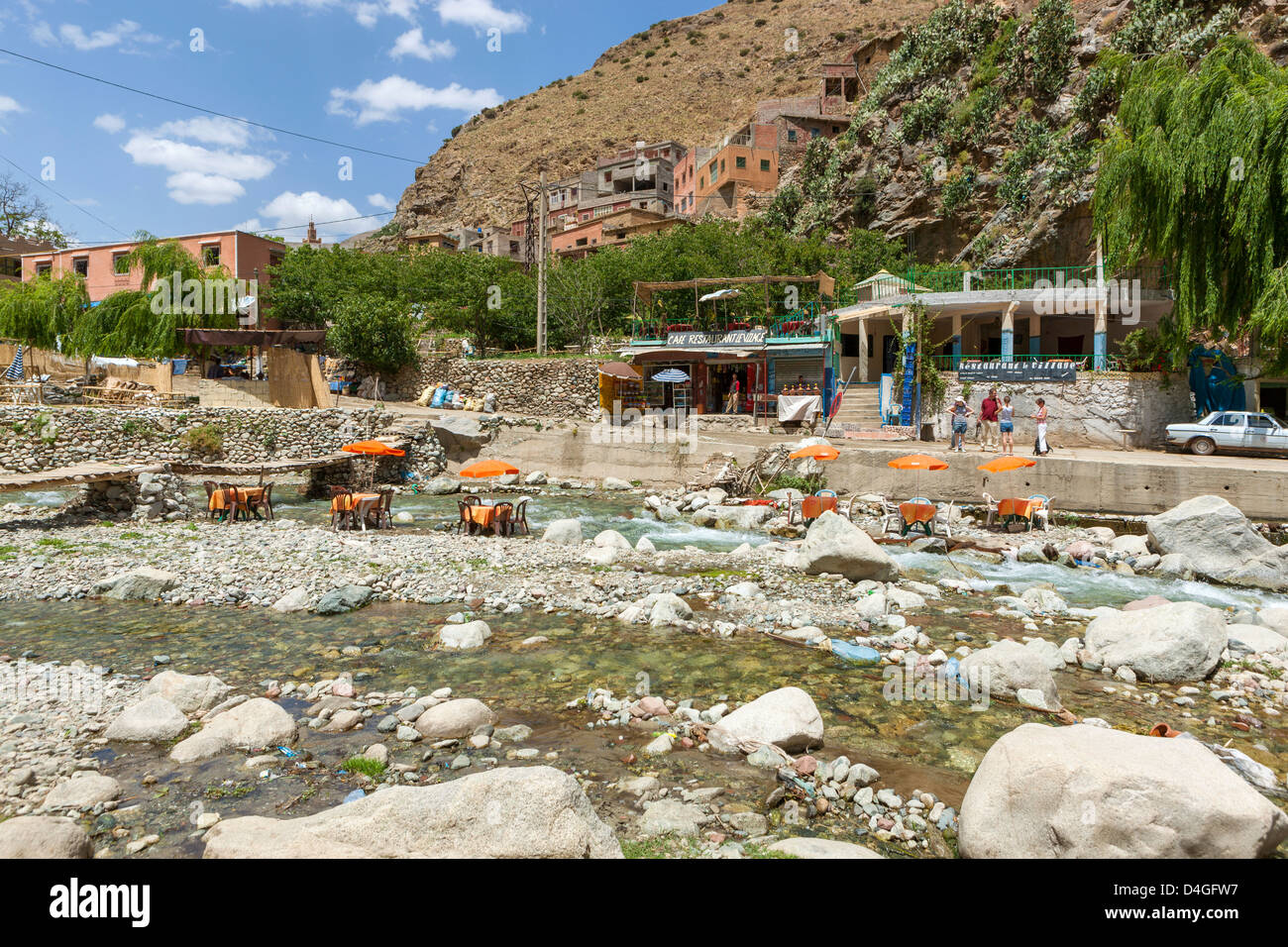 Chairs and a table at a restaurant patio overlooking mountain rapids ...