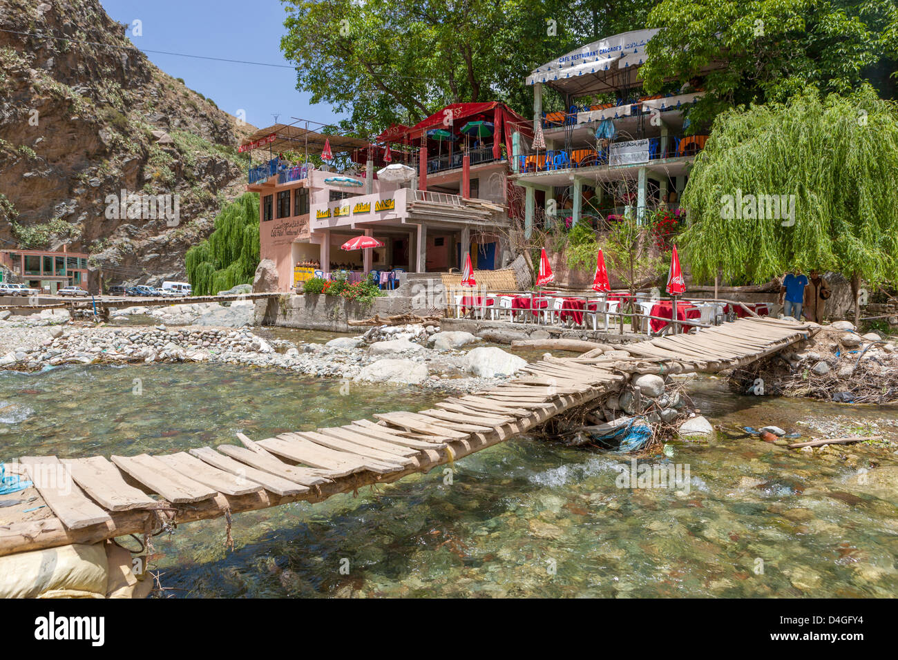 Chairs and a table at a restaurant patio overlooking mountain rapids ...