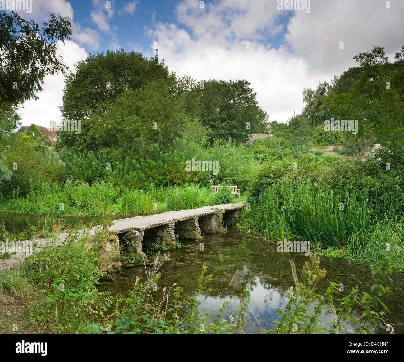 Clapper bridge crossing the River Leach in the pretty Cotswolds village ...