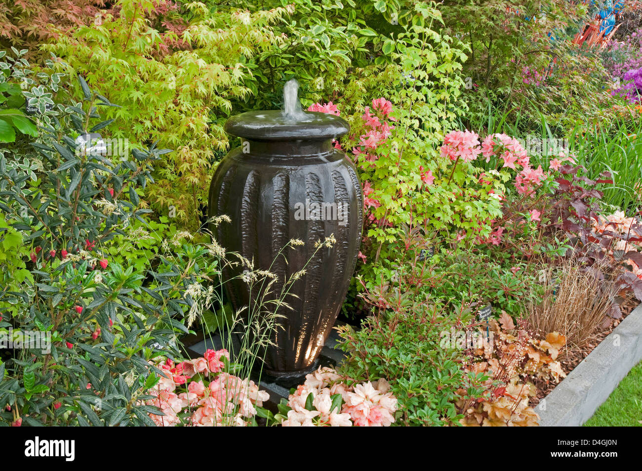 Water Feature in Spring Border of shrubs, perennials and Rhododendrons ...