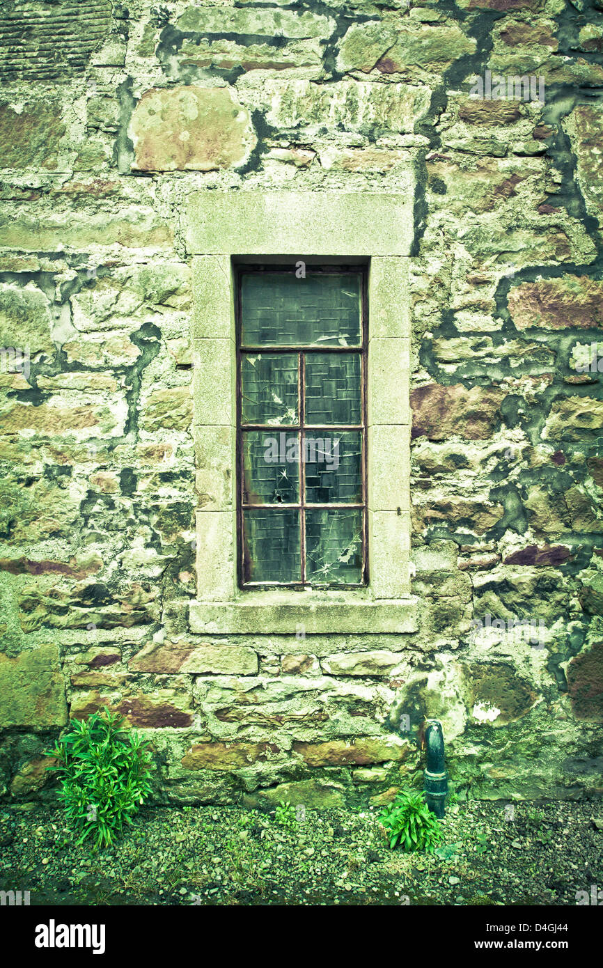 A cracked window in a derelict stone cottage Stock Photo - Alamy