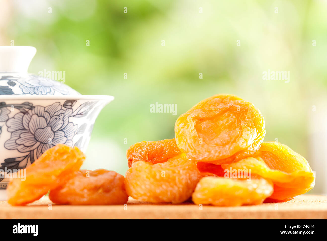 Plum candy, Chinese specialty with a cup of tea Stock Photo - Alamy