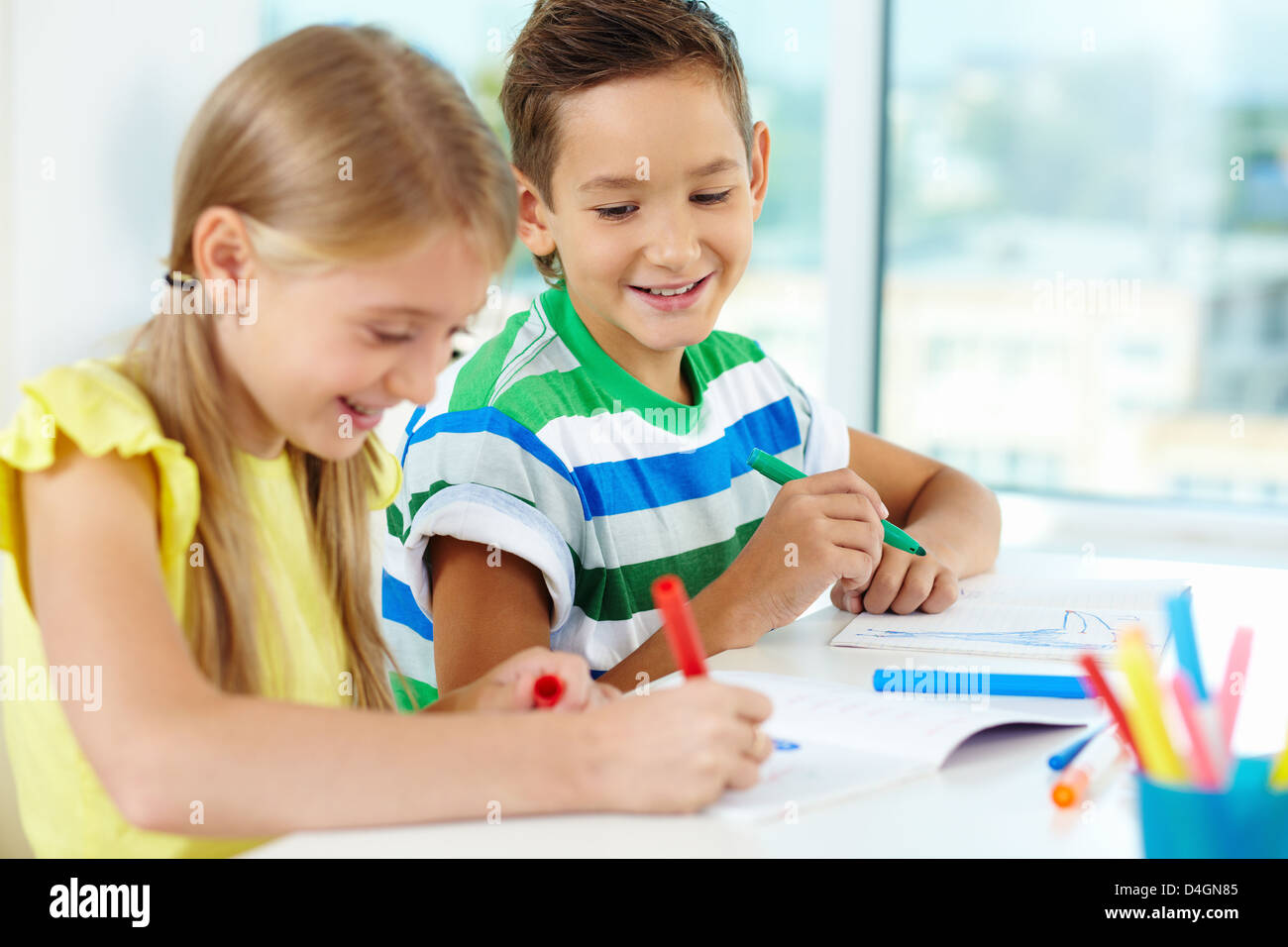 Portrait of cute schoolkids drawing at lesson Stock Photo - Alamy