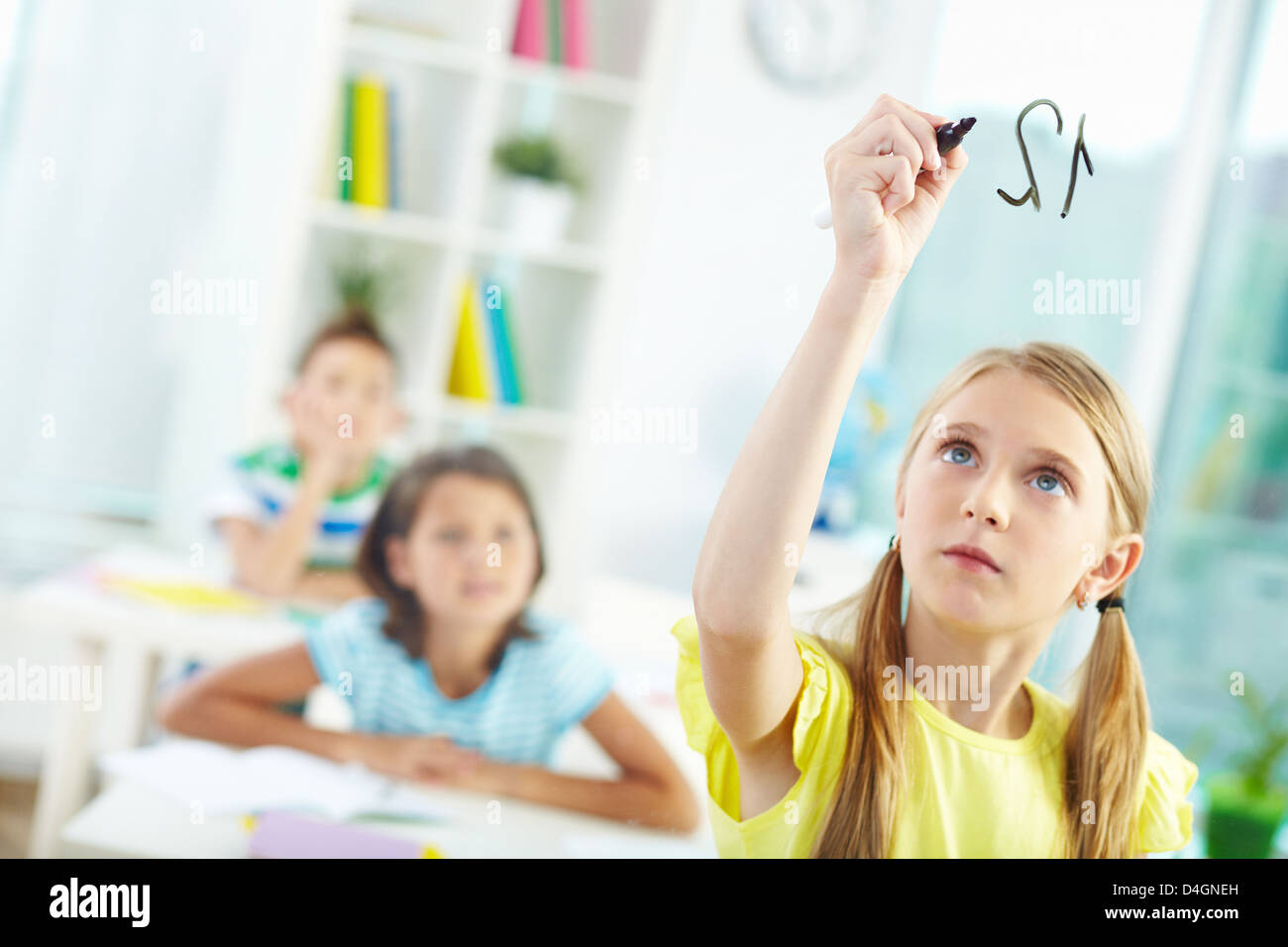 Portrait of lovely girl doing sums on transparent board with ...