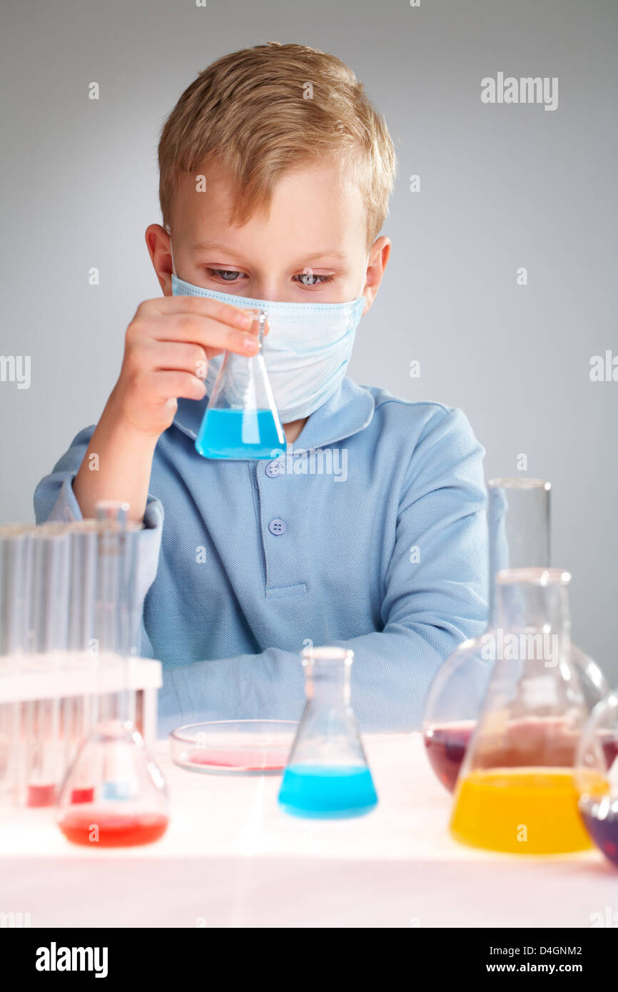 A little boy in mask looking at liquid in flask Stock Photo - Alamy