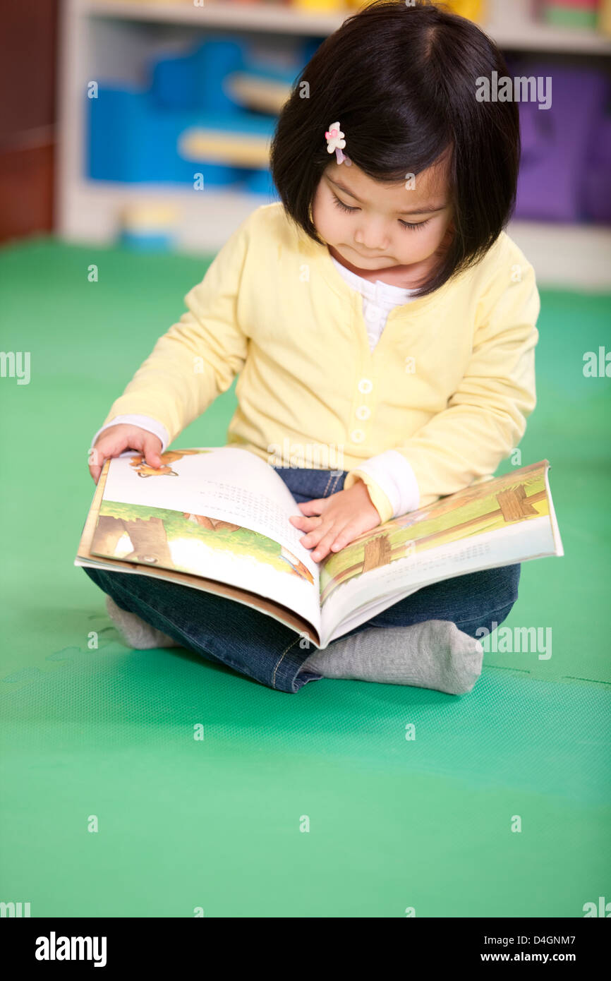 Cute little girl reading book Stock Photo - Alamy