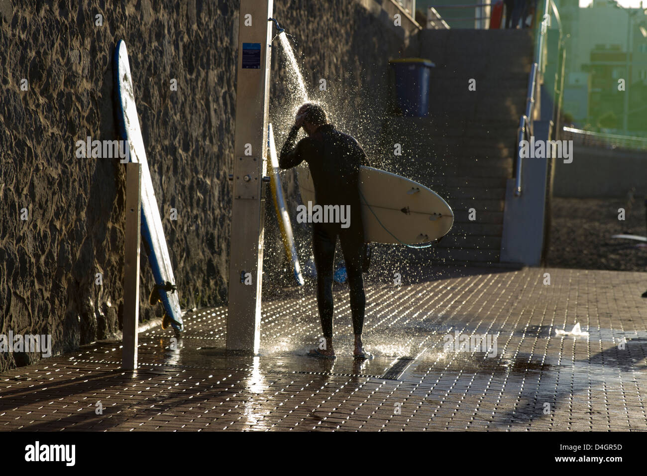 Surfer taking a shower Stock Photo - Alamy