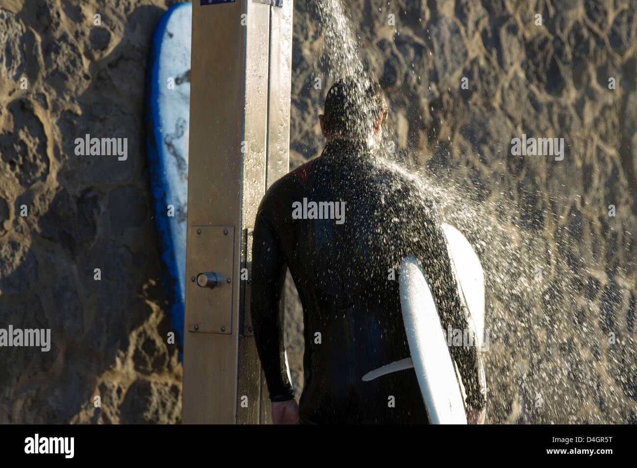 Surfer taking a shower Stock Photo - Alamy
