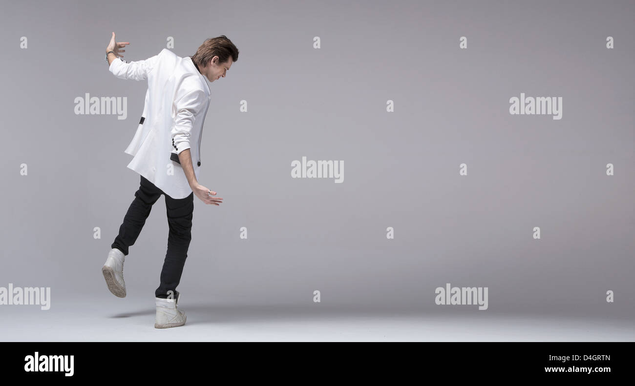 Handsome young man with jacket dancing alone Stock Photo - Alamy