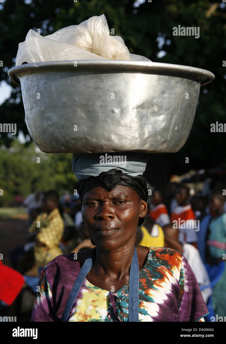 A woman balances a bowl with food on her head in Asesewa, Ghana, 20 ...