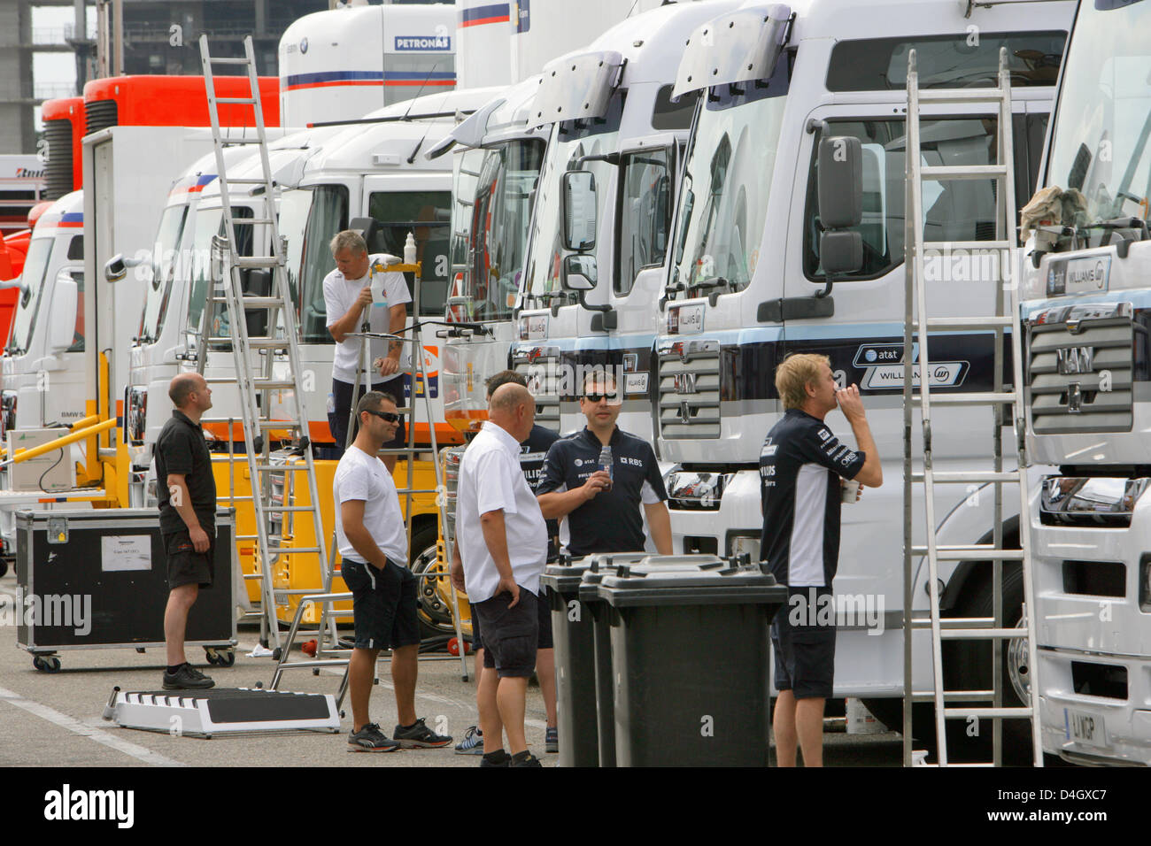 Mechanics clean the trucks in the paddock at Hockenheim race track near ...